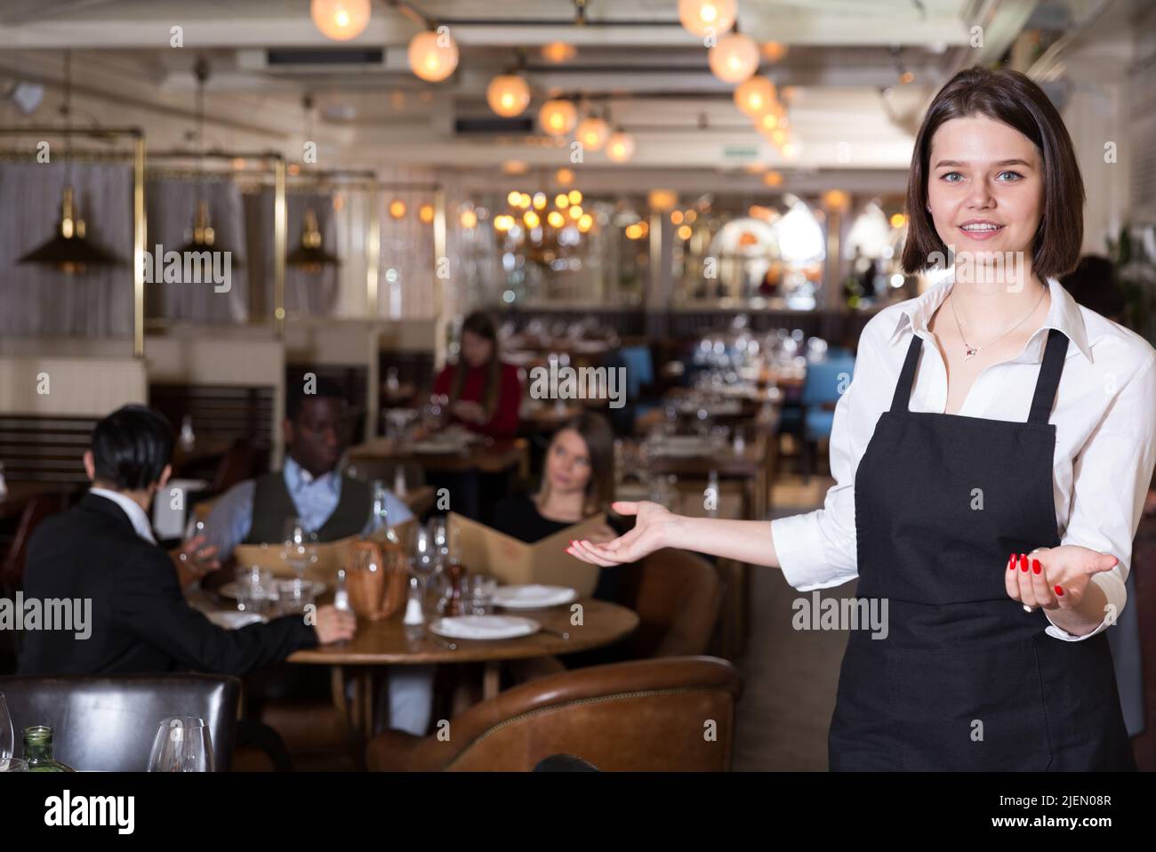 Waitress meeting customers in restaurant Stock Photo - Alamy