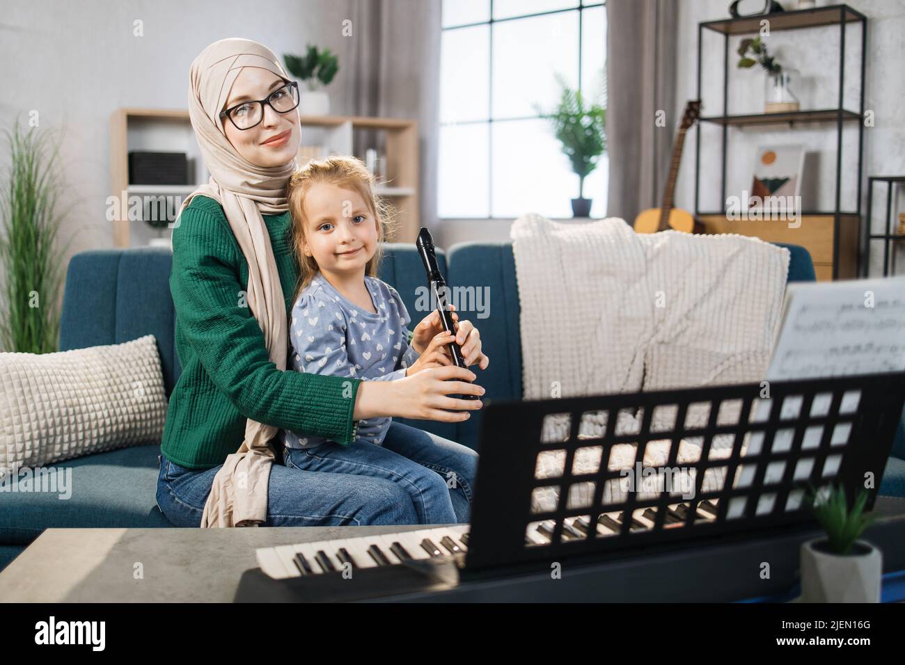 Little cute girl with music muslim teacher having lesson at flute at ...