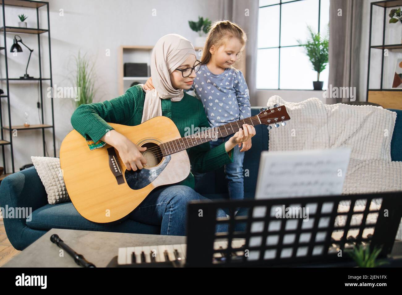 Little cute girl with music muslim teacher having lesson at guitar at ...