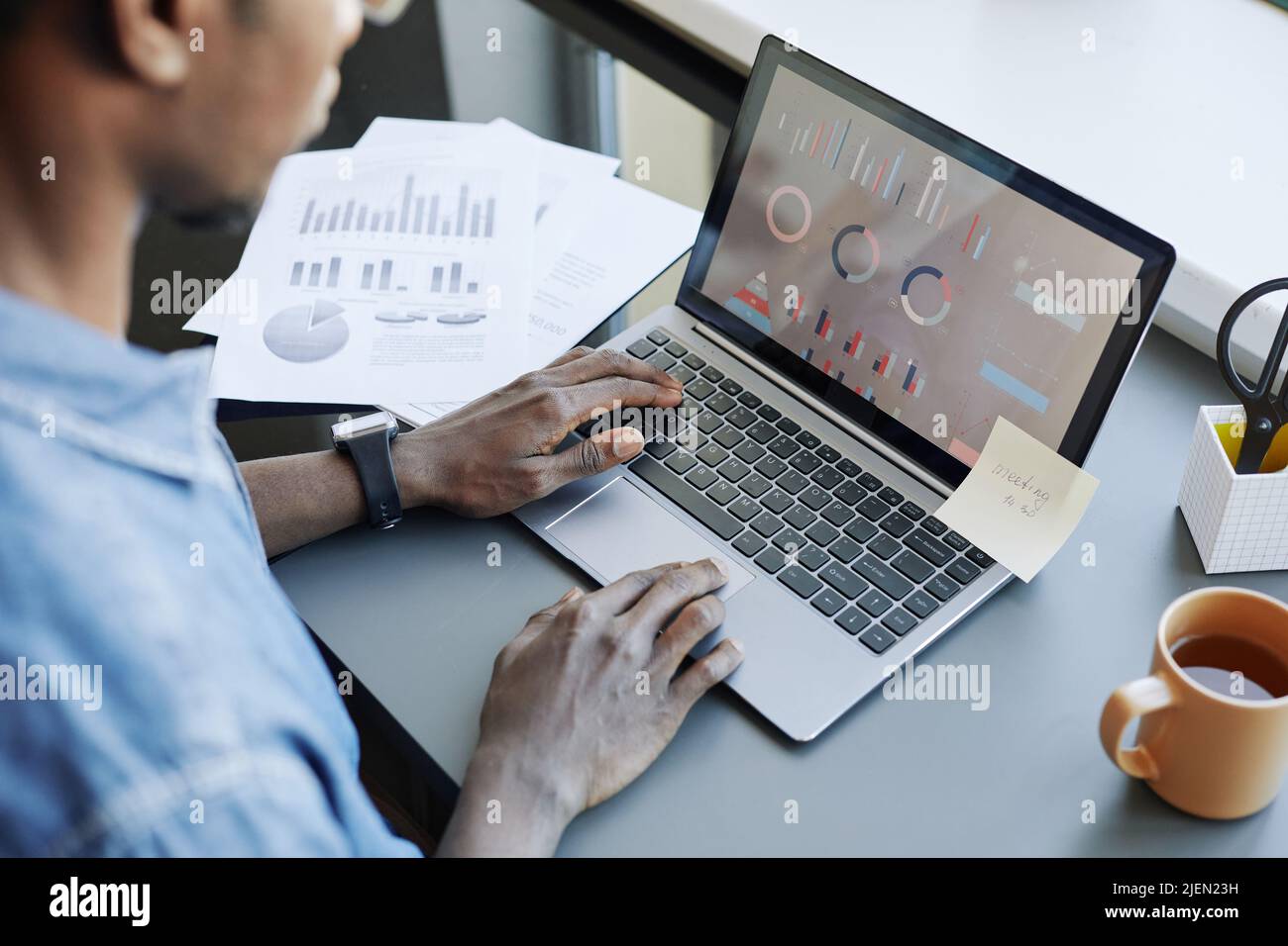 High angle view at young data analyst using computer with charts on ...
