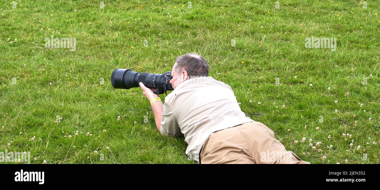 Man laying on the ground taking pictures Stock Photo - Alamy