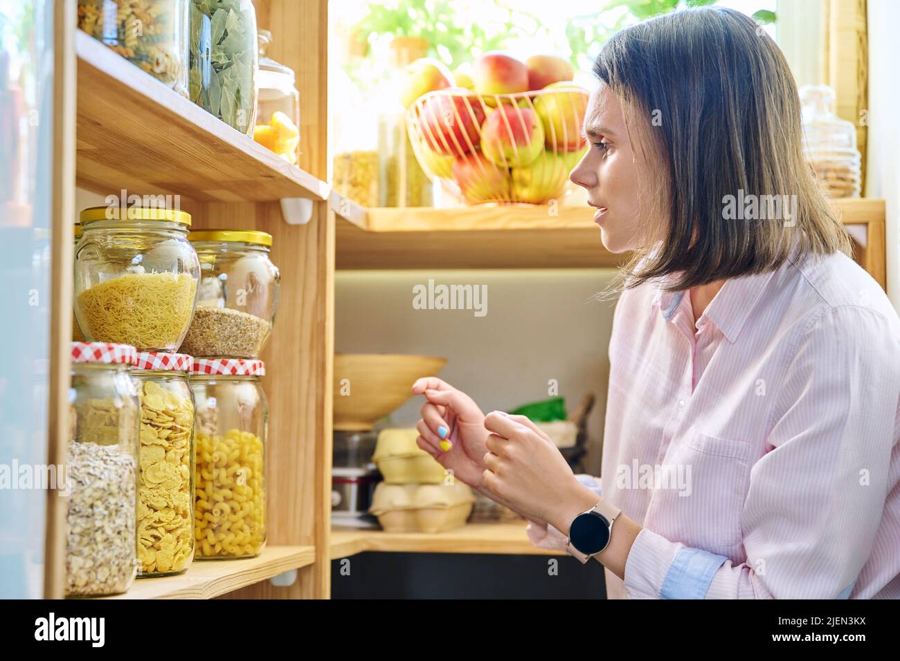 Young woman in kitchen with containers jars of food Stock Photo - Alamy
