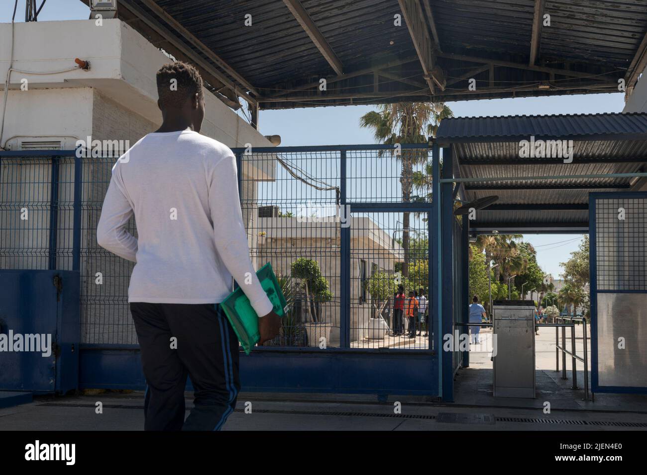 A refugee migrant enters the Temporary Stay Center for Immigrants with ...
