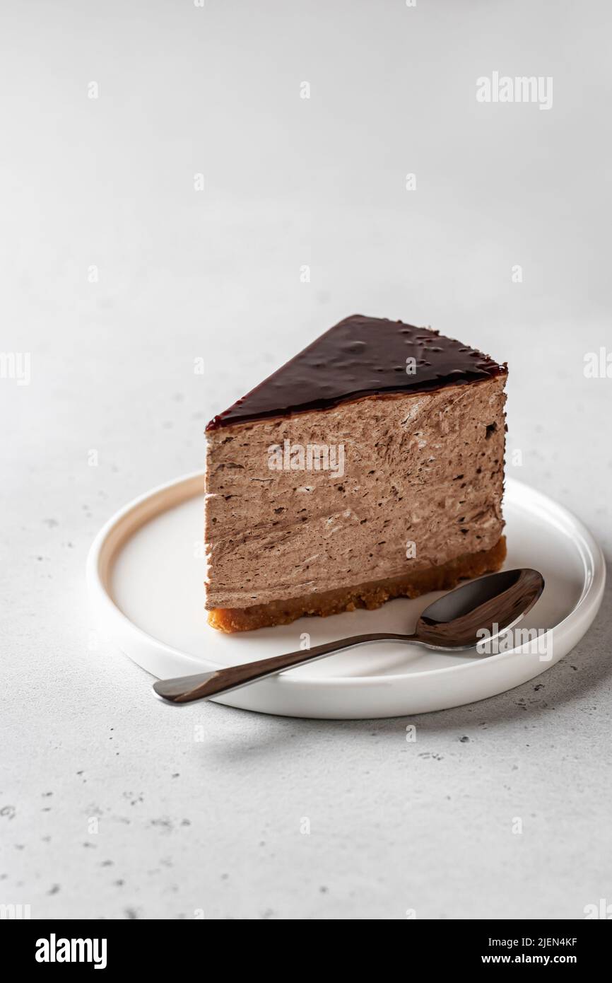 chocolate cheesecake slice glazed on white textured background with ...