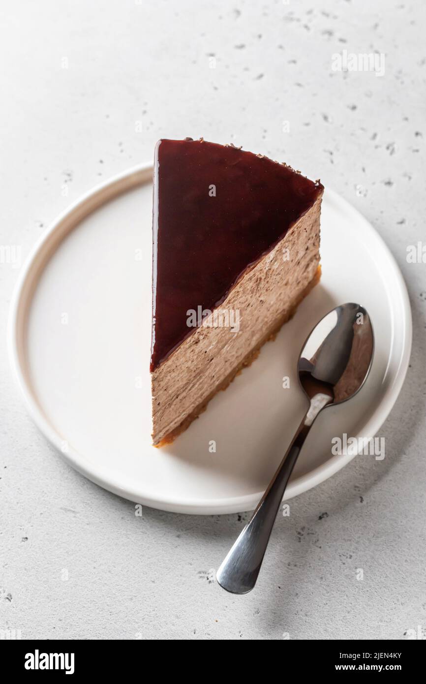 chocolate cheesecake slice glazed on white textured background ...
