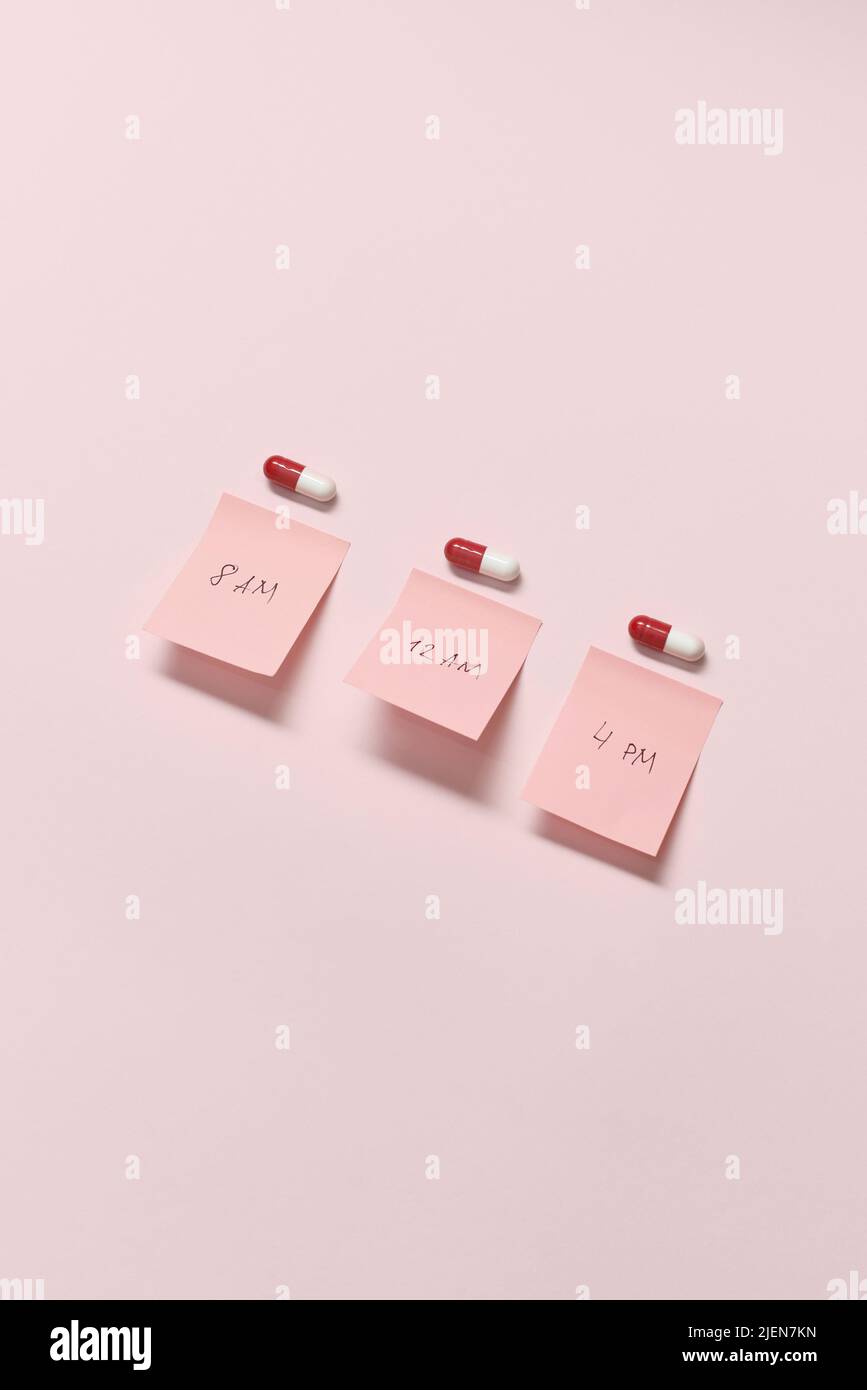 Pharmaceutical capsules and medication time notes Stock Photo - Alamy