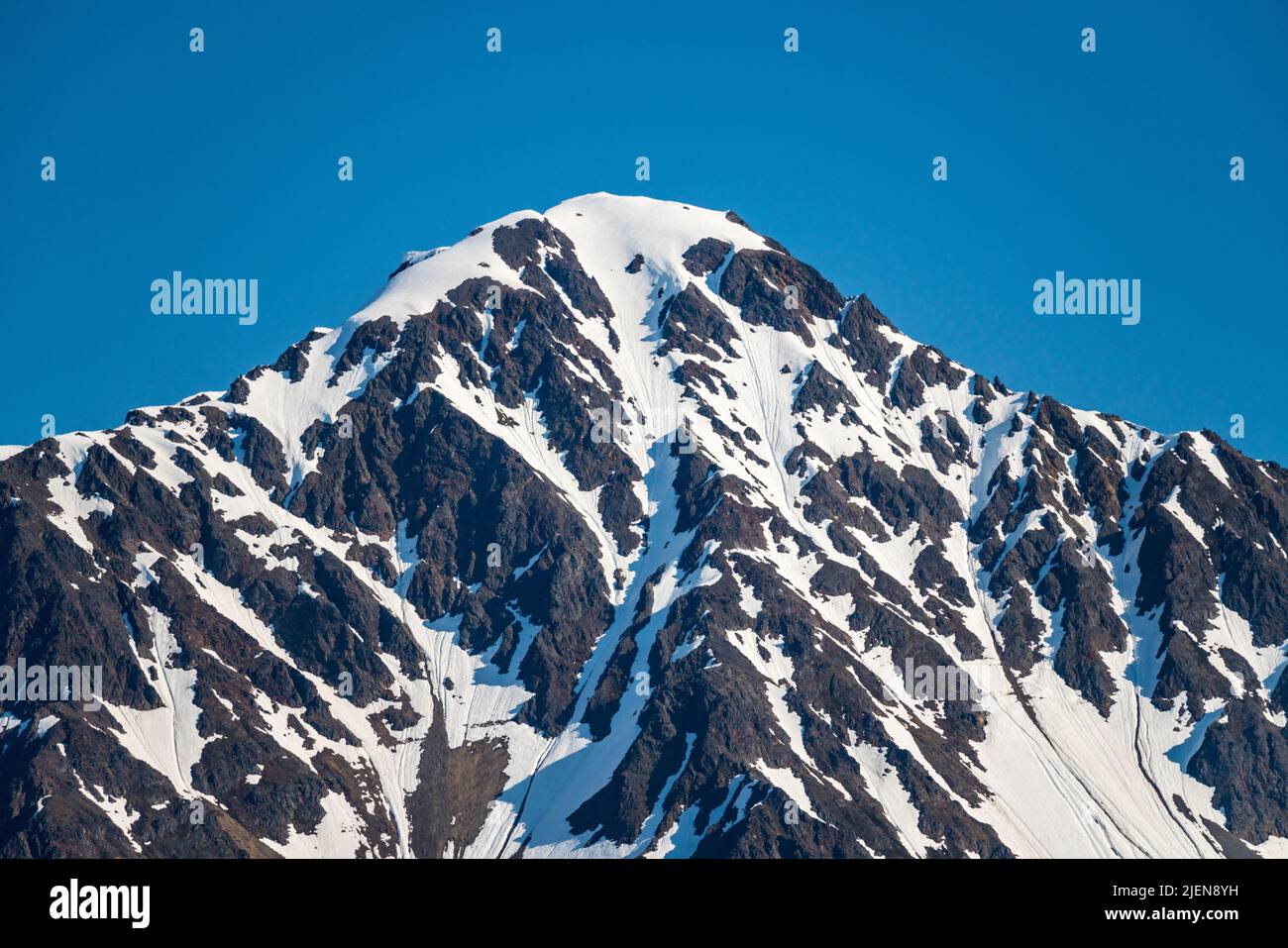 Snow covered peak of the mountain overlooking the port of Seward in ...