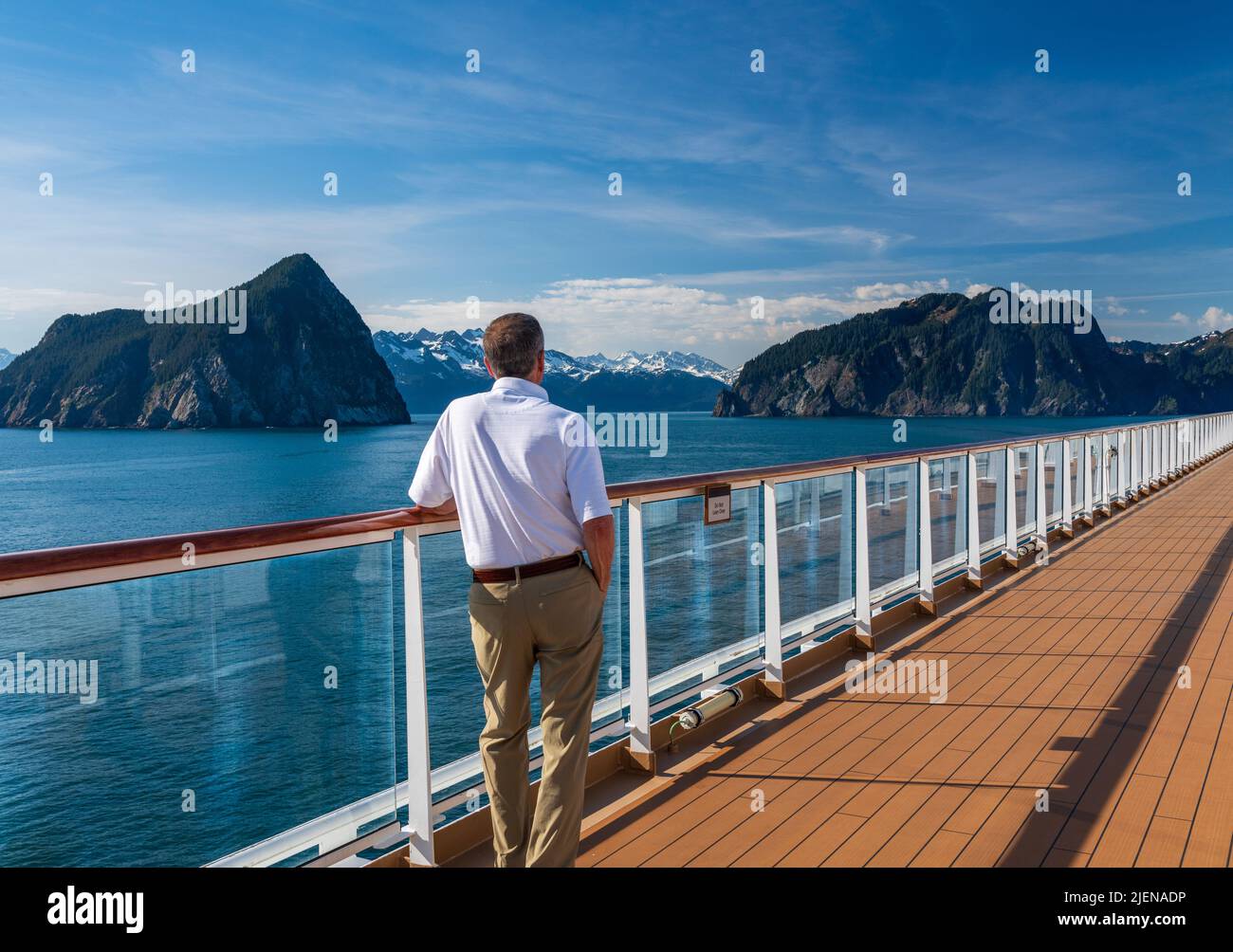 Senior adult man alone on deck of cruise ship leaving Alaskan port of ...