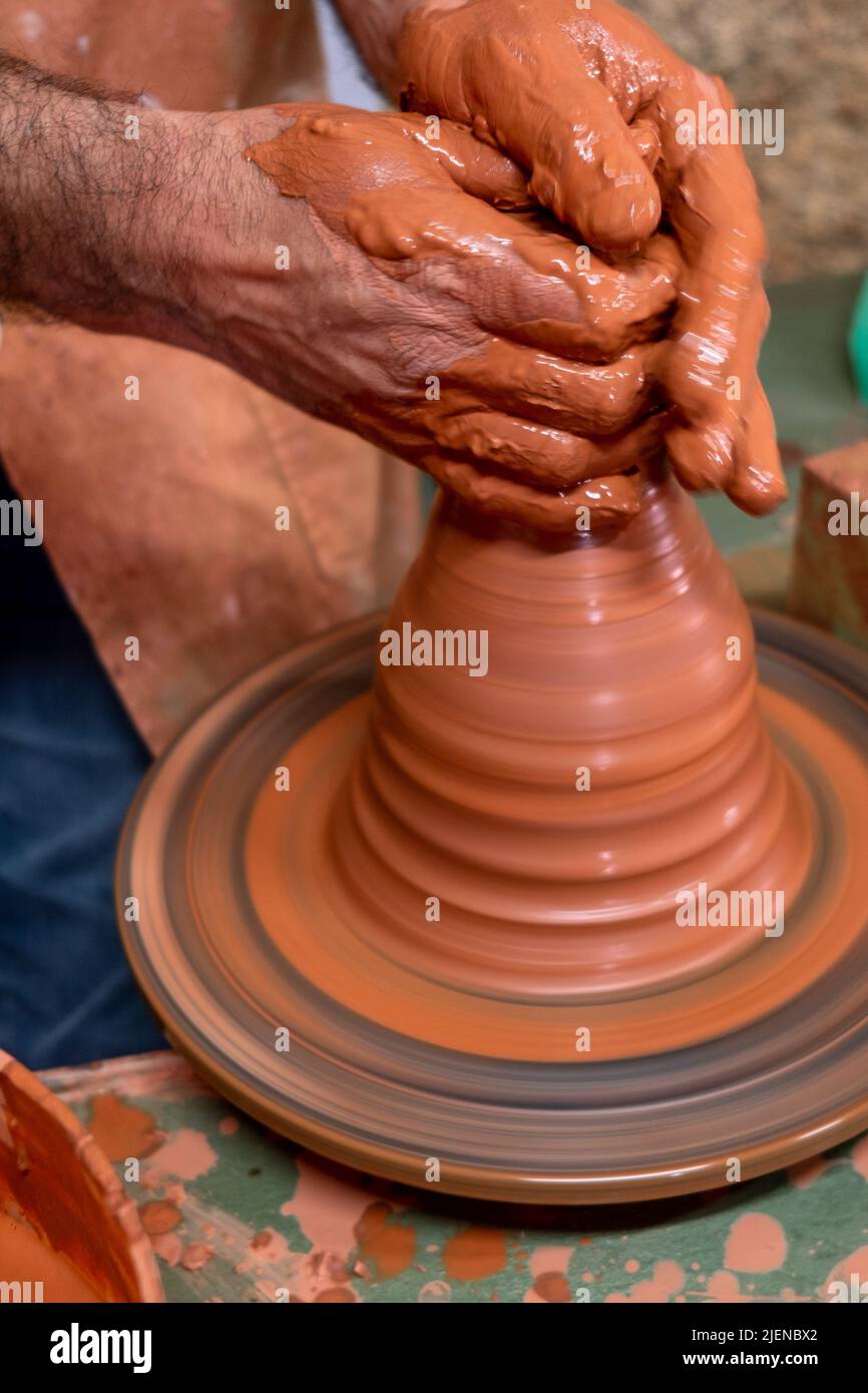 Craft hands making a clay pot. Men's hands. Potter at work. Creating ...