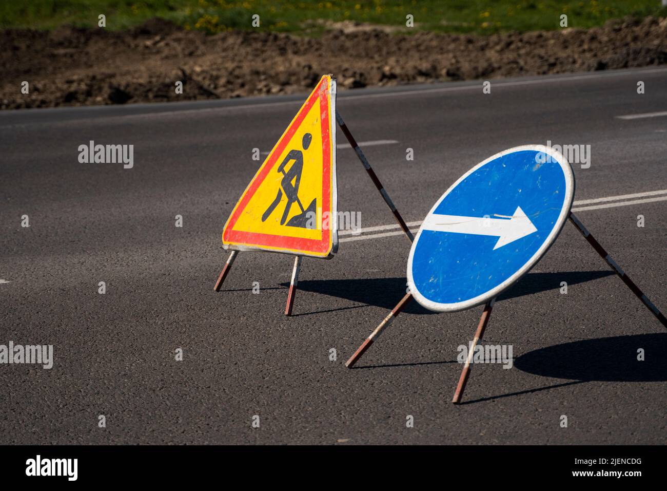 Road signs indicating the repair of asphalt and the direction to bypass ...