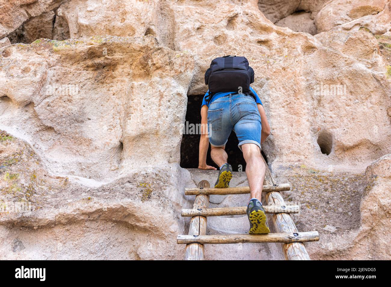 Man climbing up ladder on Main Loop trail hike in Bandelier National ...