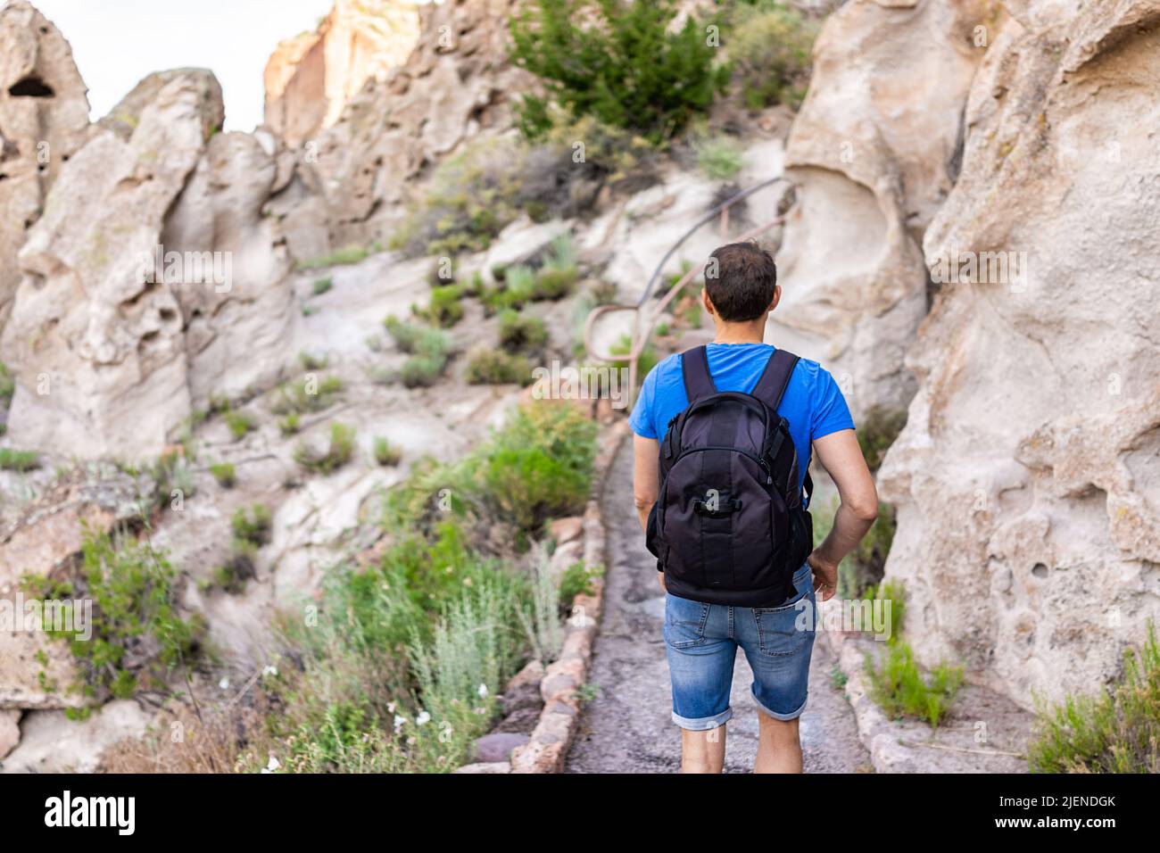 Back of man hiking walking on Main Loop trail hike in Bandelier ...