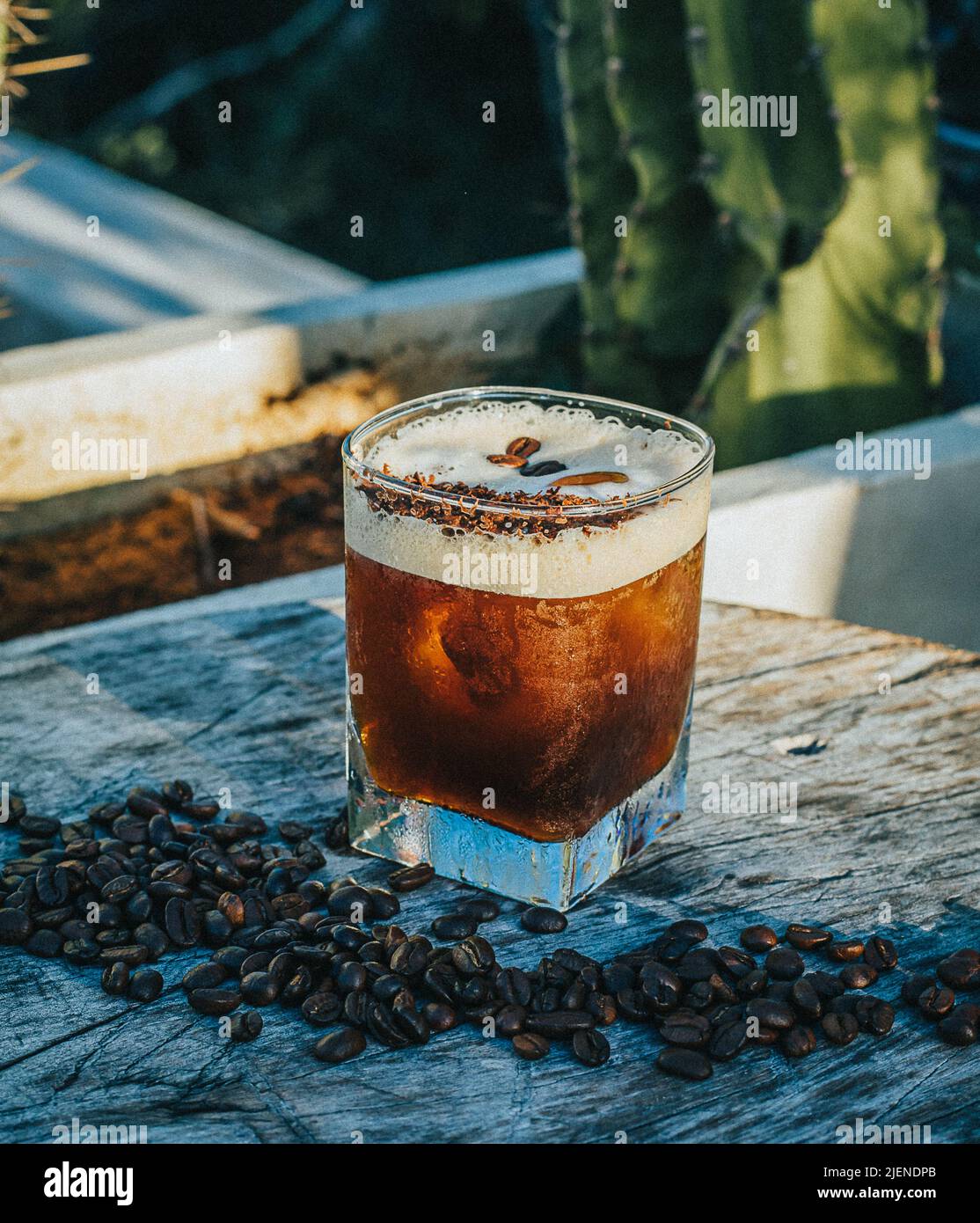 Tropical iced cocktail made of fresh coffee with coffee beans on a wood ...