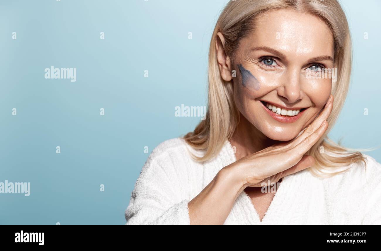 Rejuvenation and skincare. Beautiful middle aged woman, 50 years, apply ...