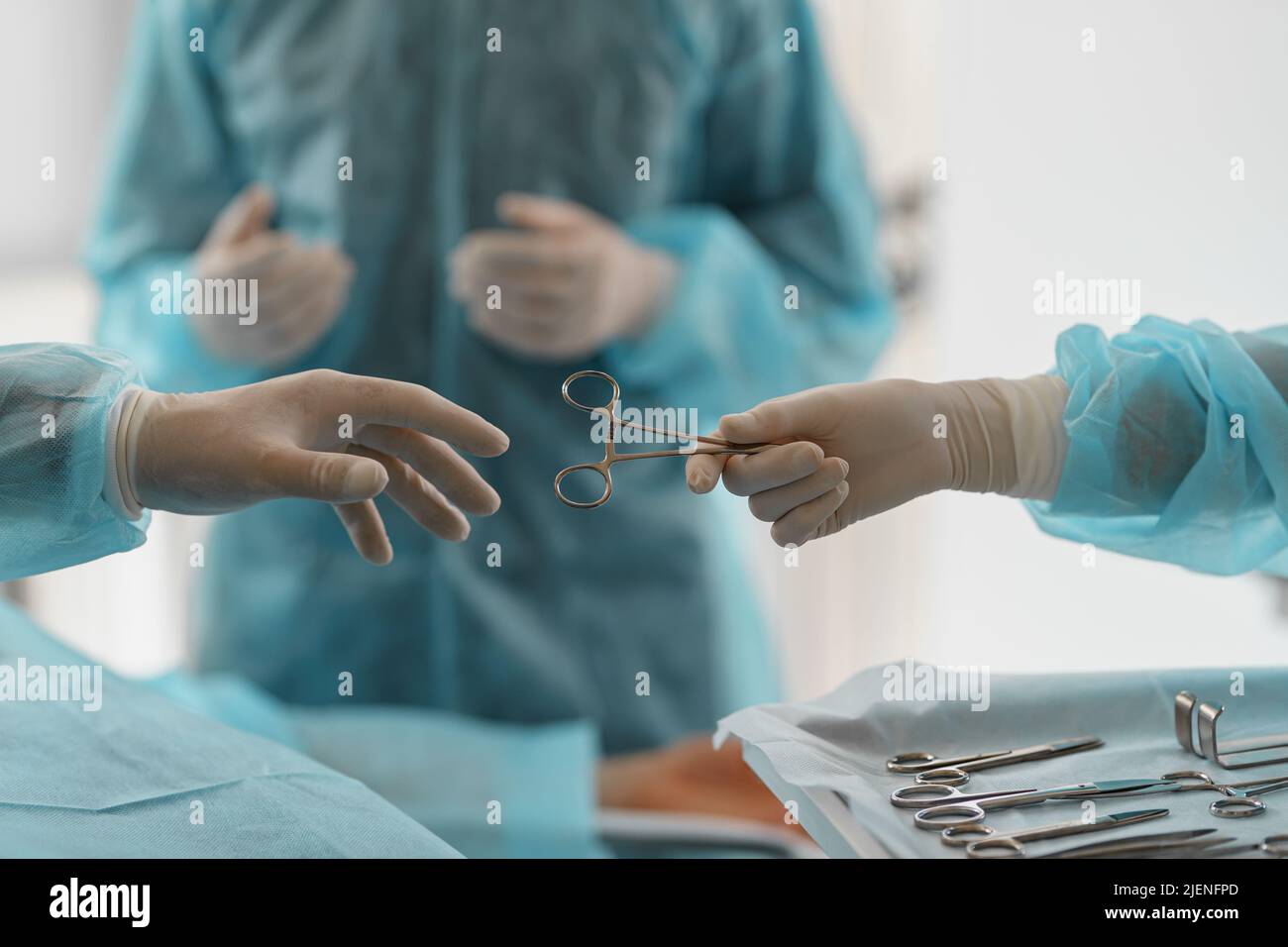 Assistant hands out instruments surgeon during surgery in the operating ...