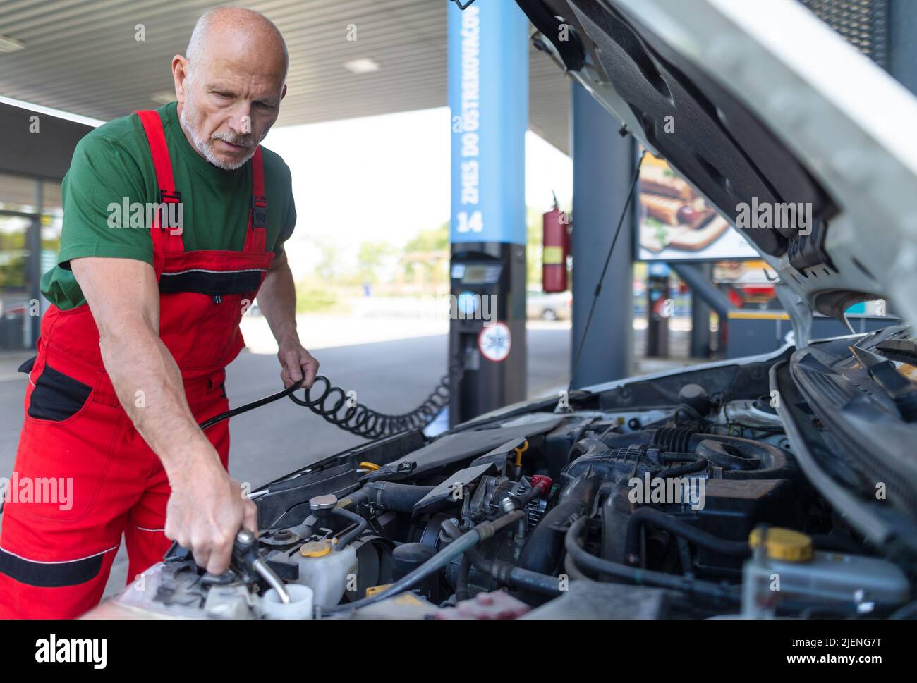 Senior mechanic checking the oil level in the car engine Stock Photo ...