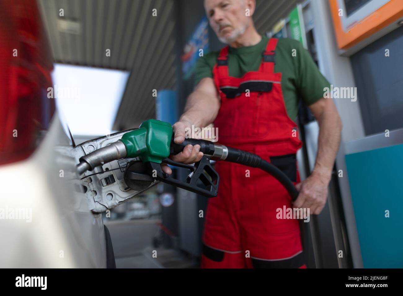 Senior worker standing on gas station and fueling car Stock Photo - Alamy