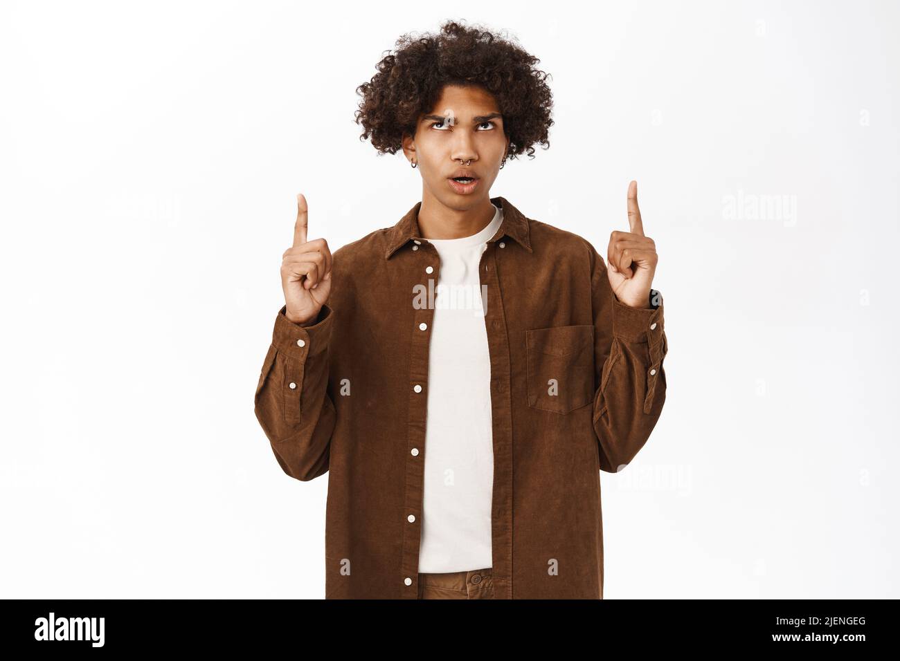 Man points up and looks confused on top, frowns puzzled, stands over ...