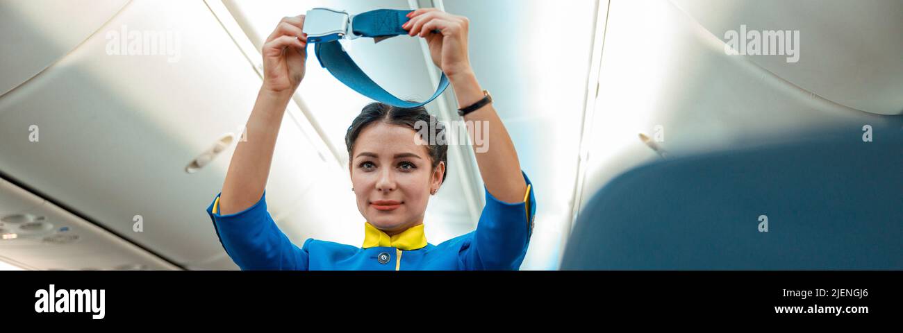 Woman stewardess demonstrating how to use safety belt in aircraft Stock ...