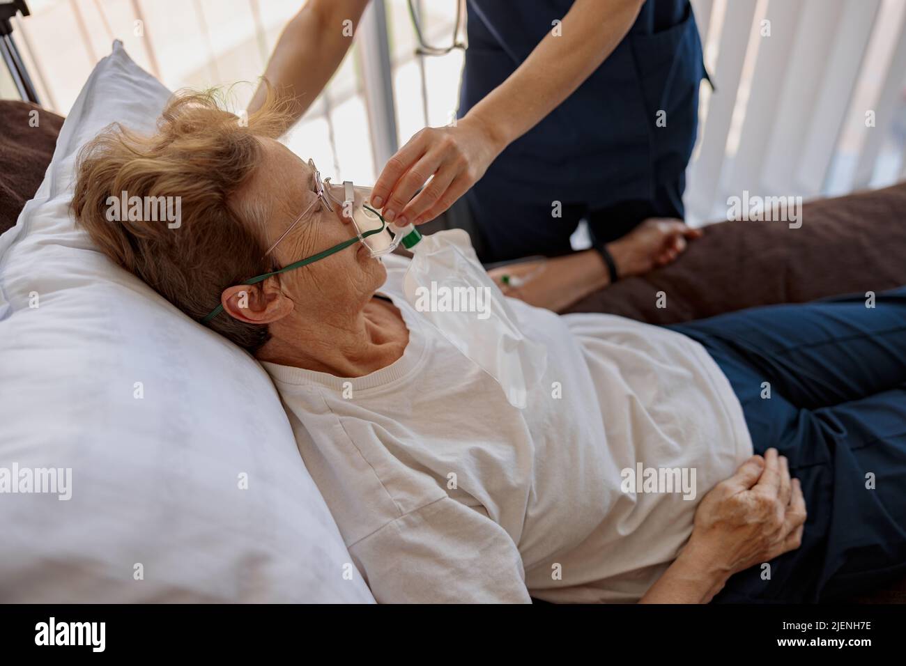 Doctor putting a breathing mask on a female patient with covid-19 Stock ...