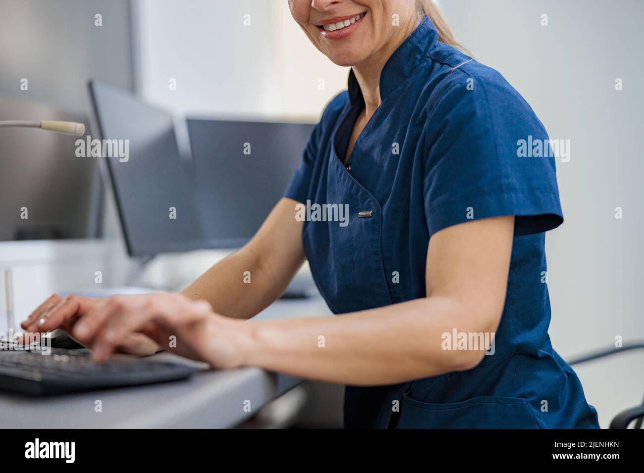 Close up of nurse on Duty working on computer at the Reception Desk in ...