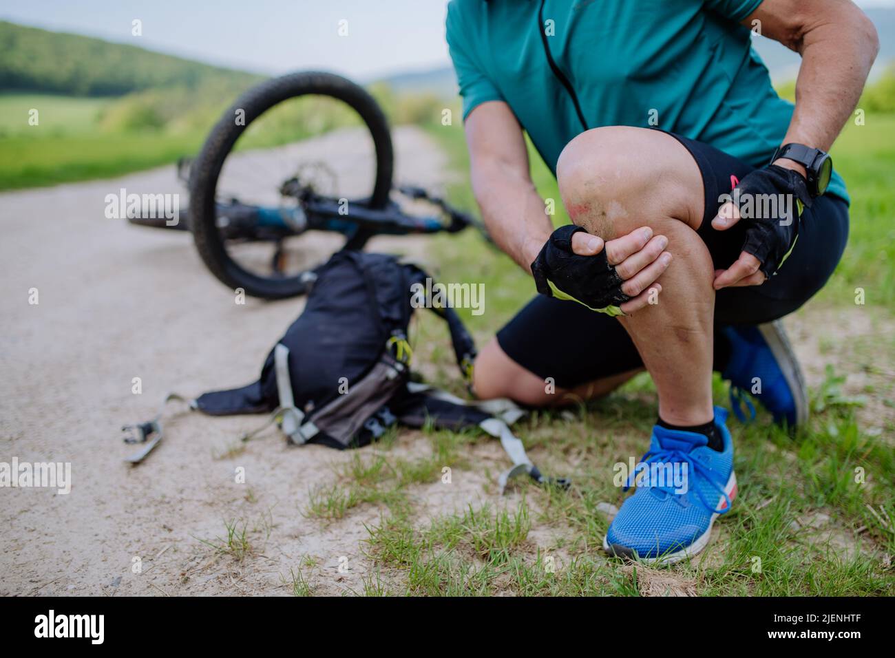 Active senior man in sportswear fell off bicycle on the ground and ...