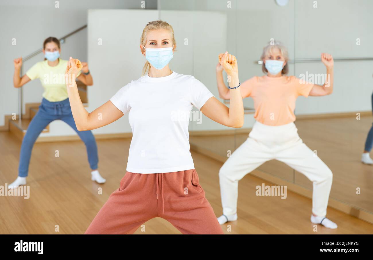Family in protective masks are engaged in sports dancing in gym Stock ...