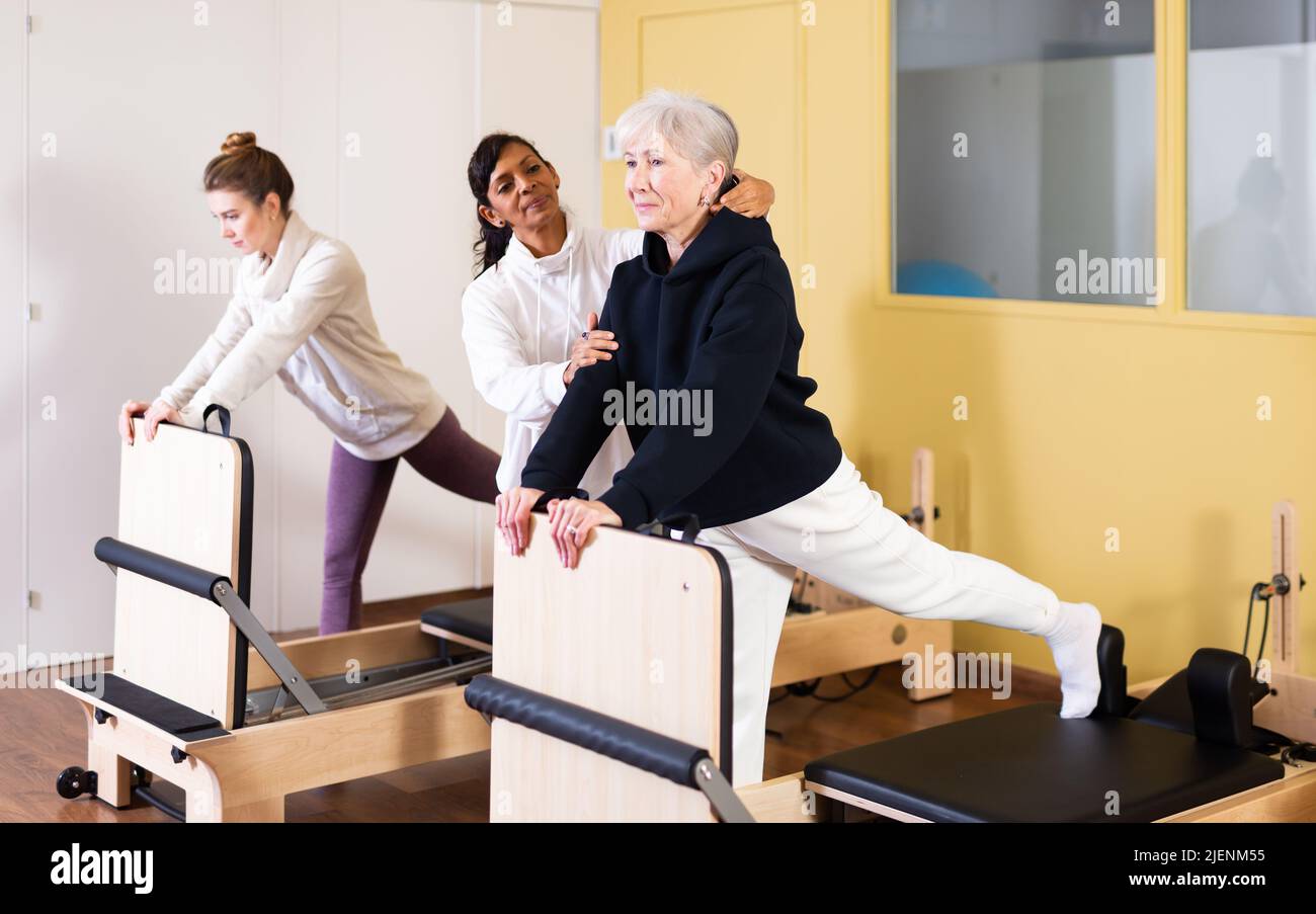 Two active women perform an exercise using a reformer bed Stock Photo ...
