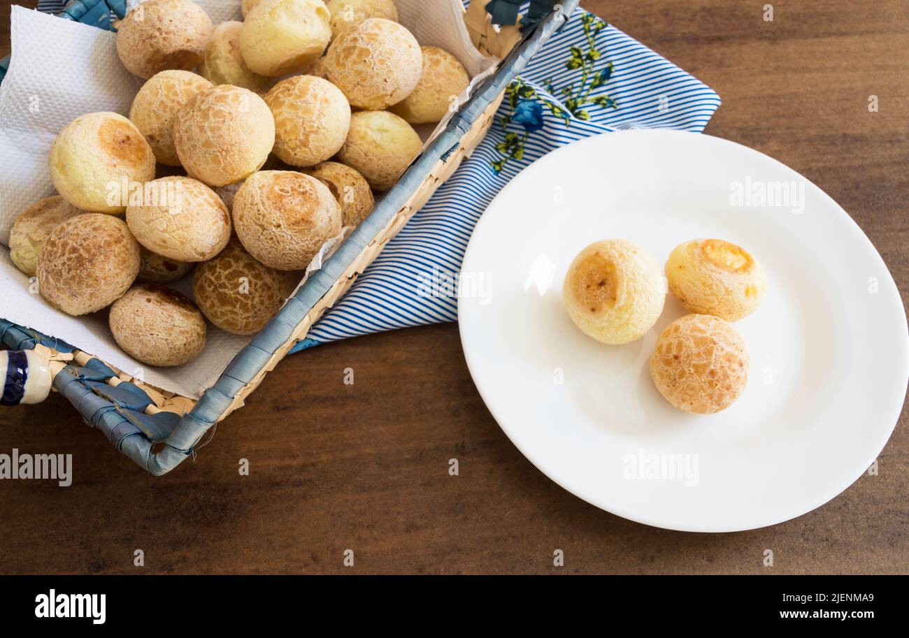 Cheese breads inside a basket and three separate breads inside a white ...