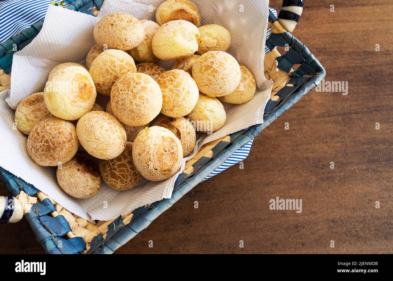 Portion of small cheese breads inside a rectangular basket on the left ...