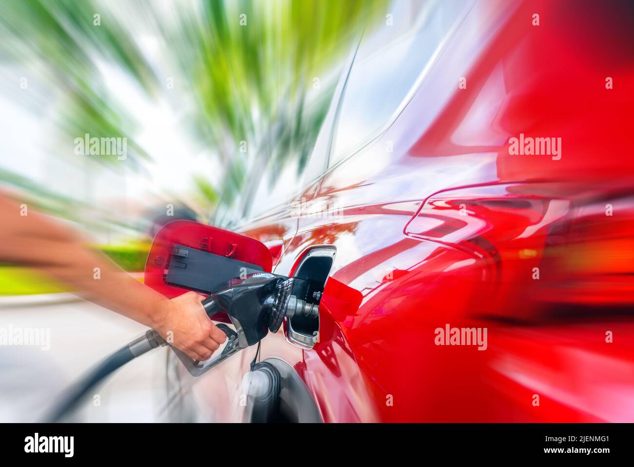 Female Hand with fuel pistol and red car with motion blur effect Stock ...