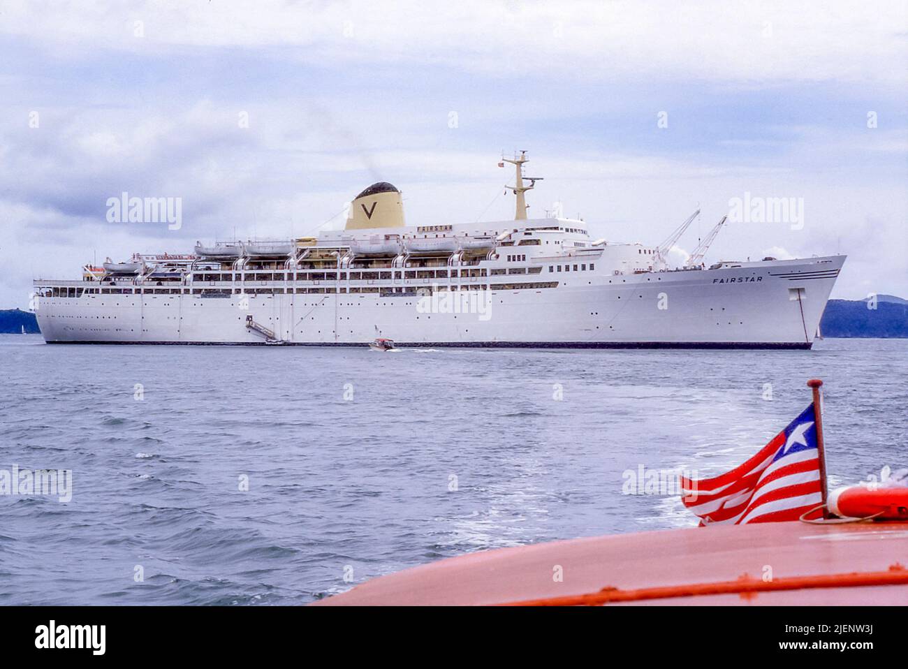 Looking astern over the roof and flag of a tender from the cruise ship ...