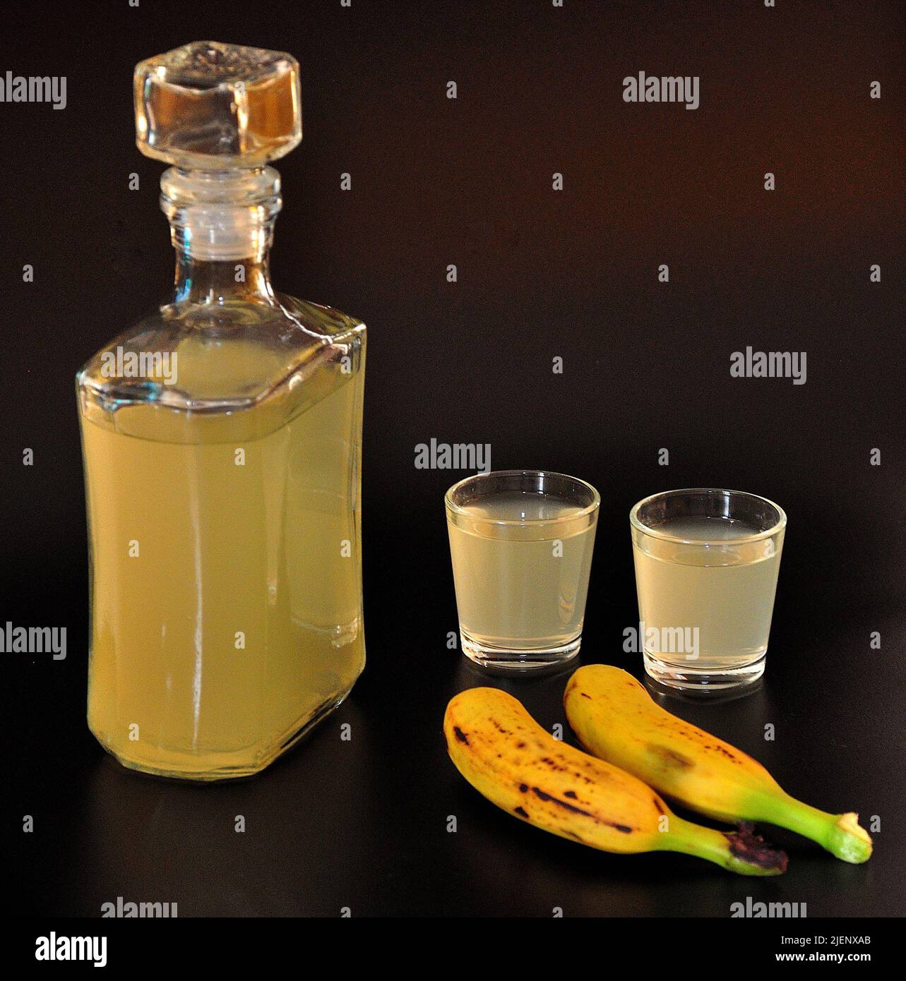 Banana liqueur, strong homemade alcohol and ripe fruits next to a ...