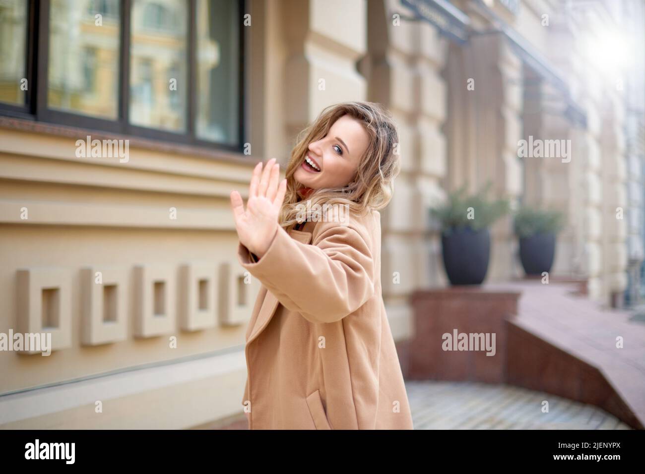 woman walk on street of city and waving goodbye or hello. woman hand ...