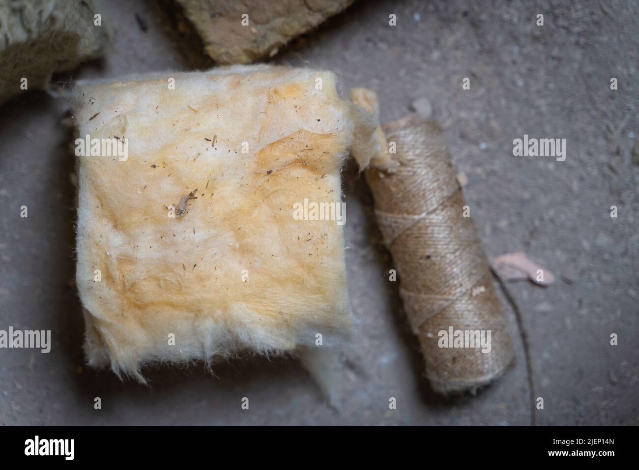 Close-up of a square cut of yellow glass wool against the background of ...