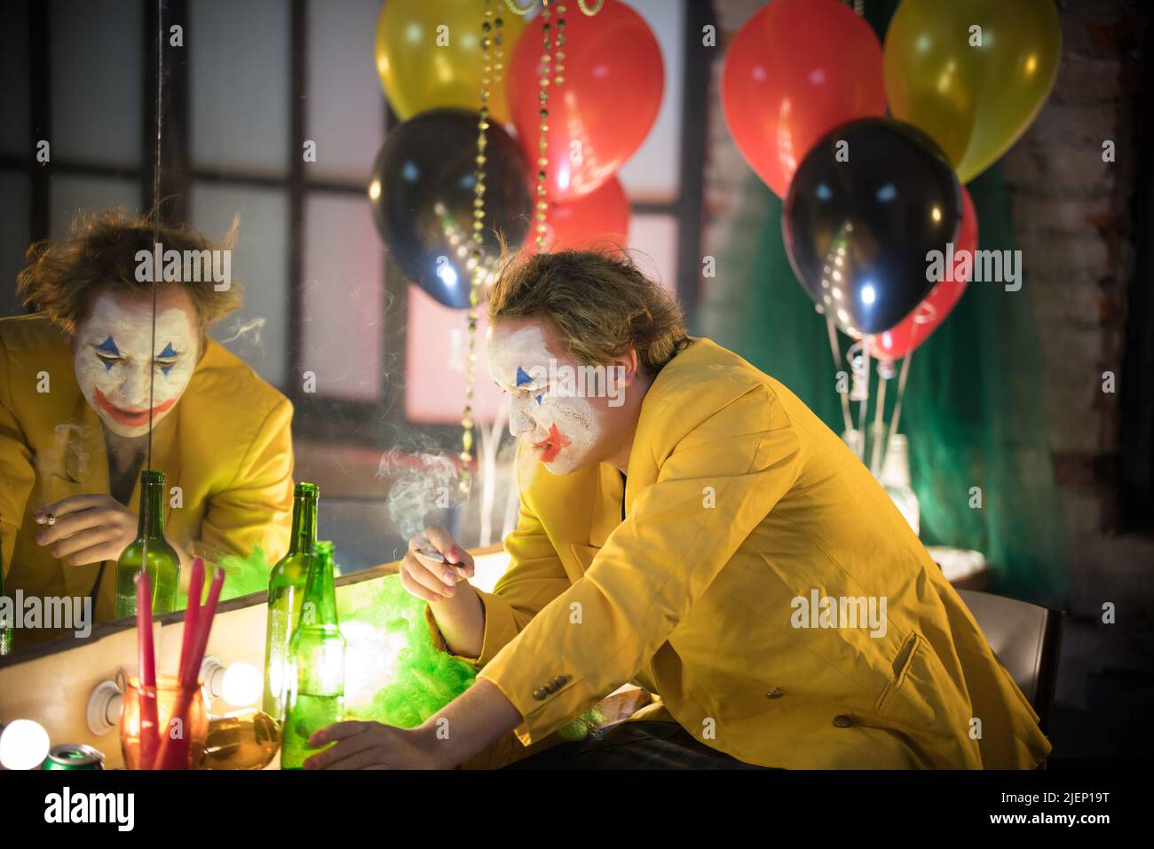 Clown concept - a tired man clown in yellow jacket smoking in the ...
