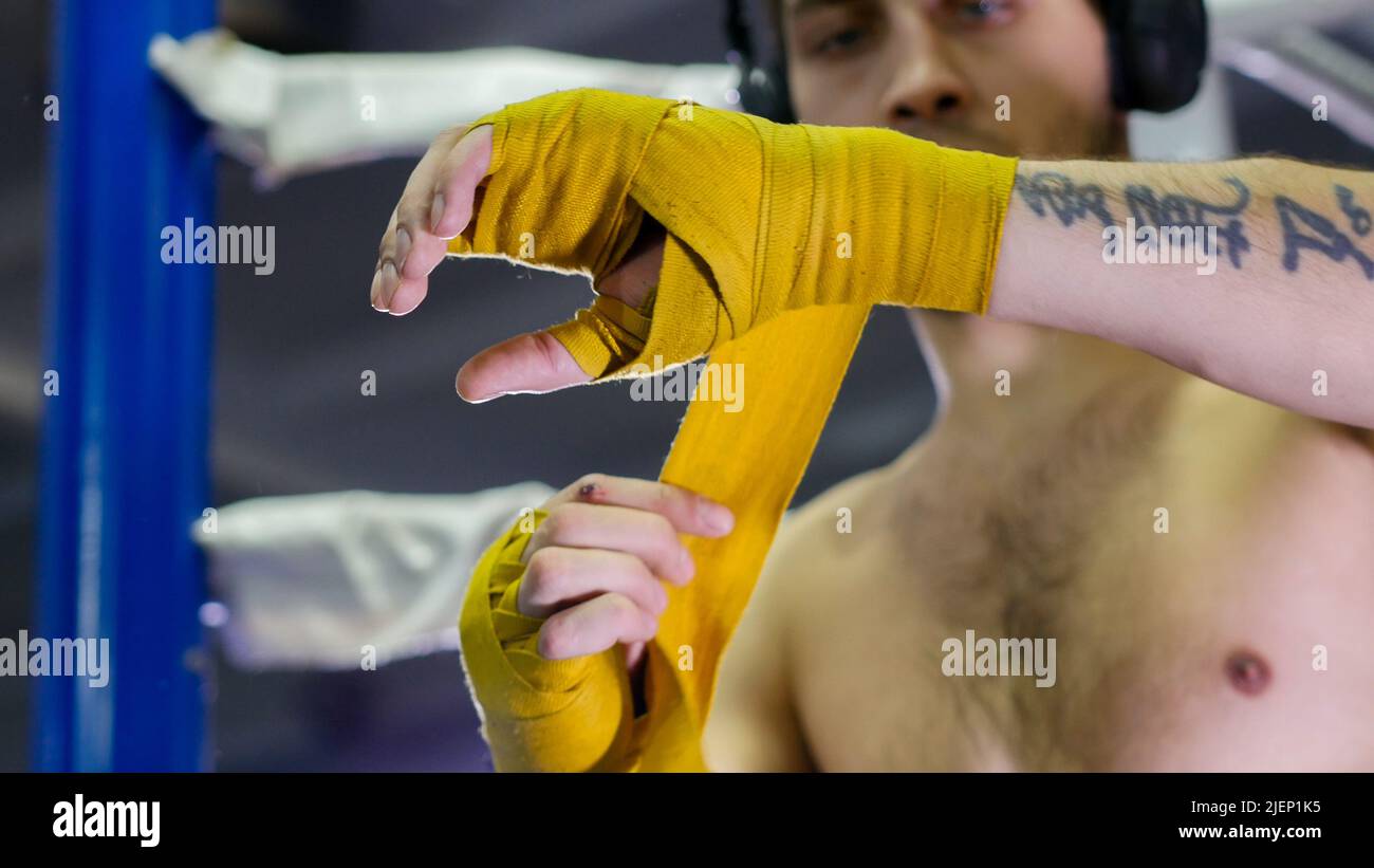 BOX - boxer with a tattoo is bandaging his arm with a yellow bandage ...