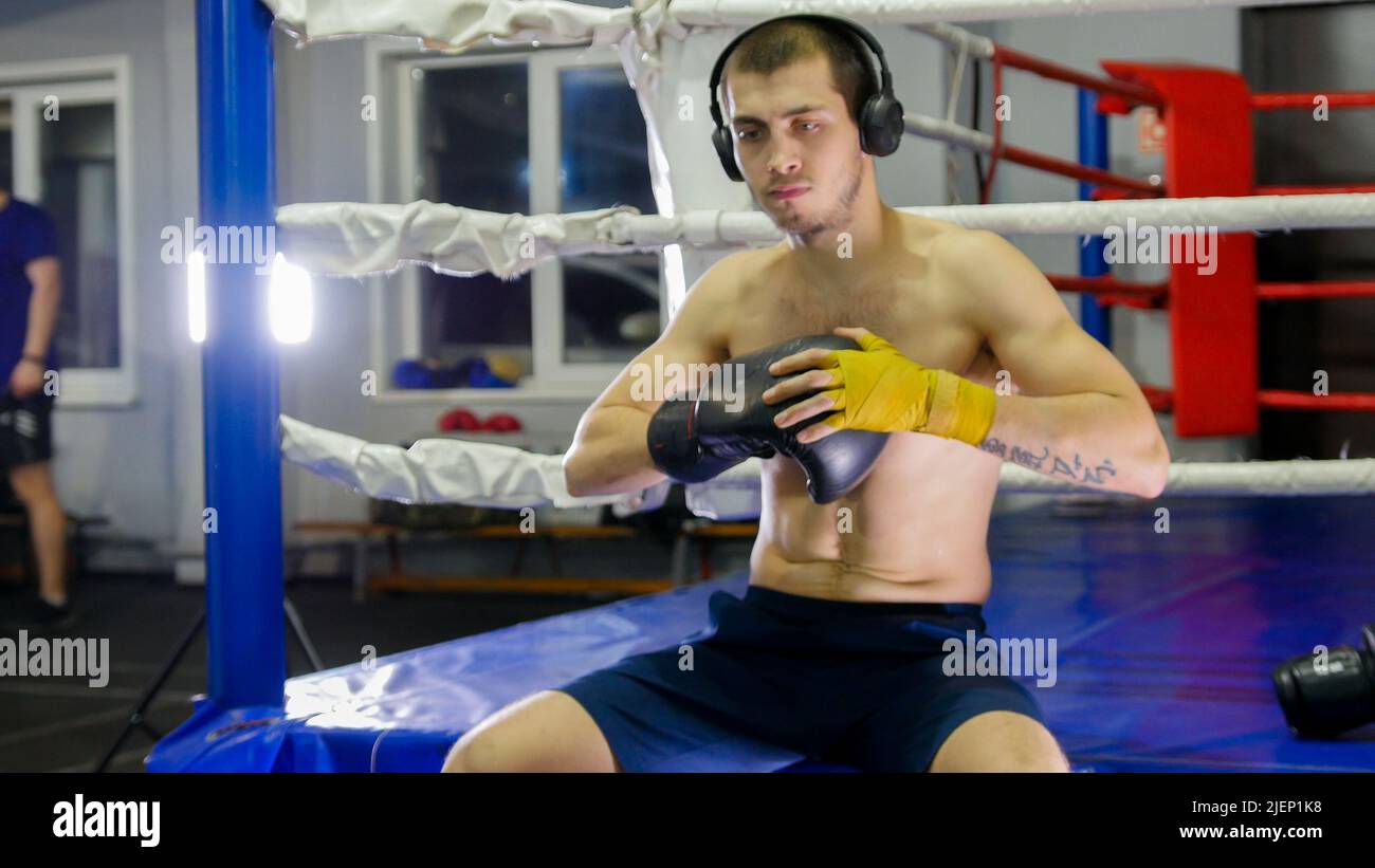 BOX - boxer is putting black gloves on his hand Stock Photo - Alamy