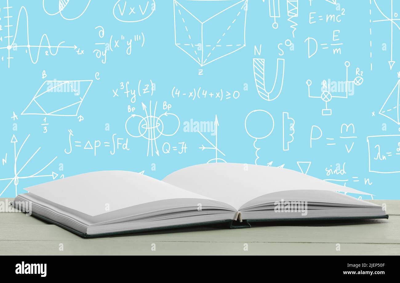 Open book on table against blue background with drawings and formulas ...