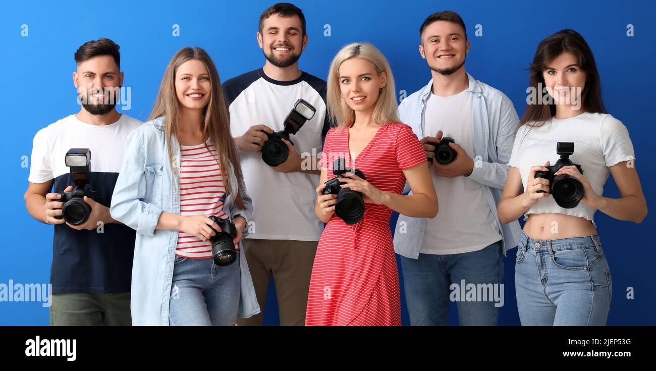 Group of young photographers on blue background Stock Photo - Alamy
