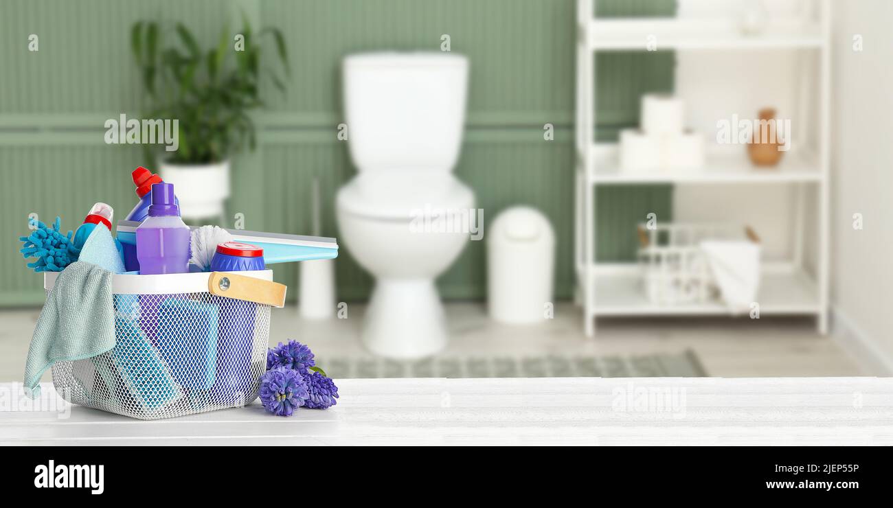 Set of cleaning supplies and spring flowers on table in bathroom Stock ...