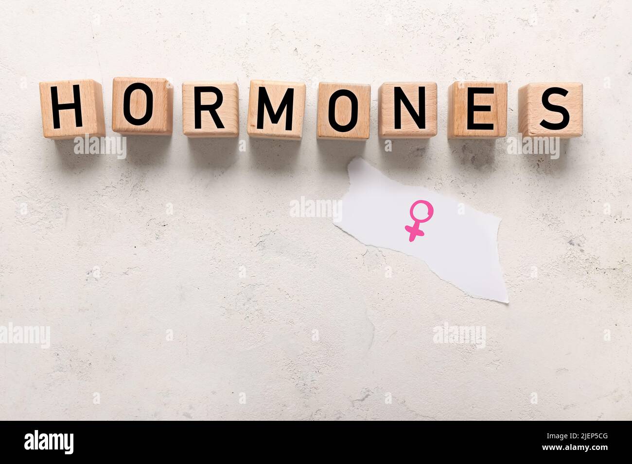 Word HORMONES made of cubes and symbol of woman on light background ...