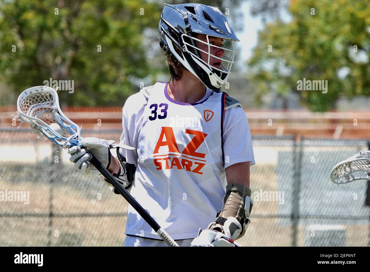 A teenage boy wearing full padding including a helmet plays the sport ...