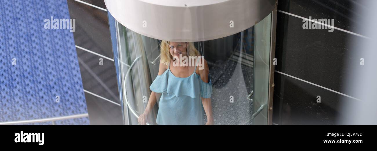Beautiful woman in the glass elevator of the building Stock Photo - Alamy