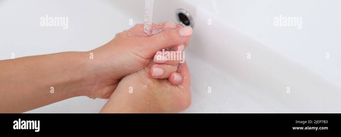 A woman washes her hands under the tap Stock Photo - Alamy