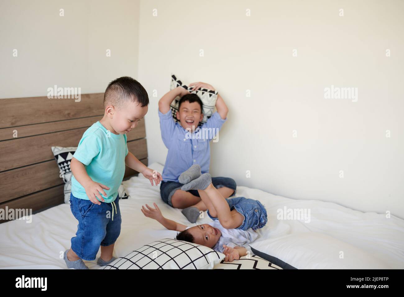 Happy excited siblings playing on bed and fighting with pillows Stock ...
