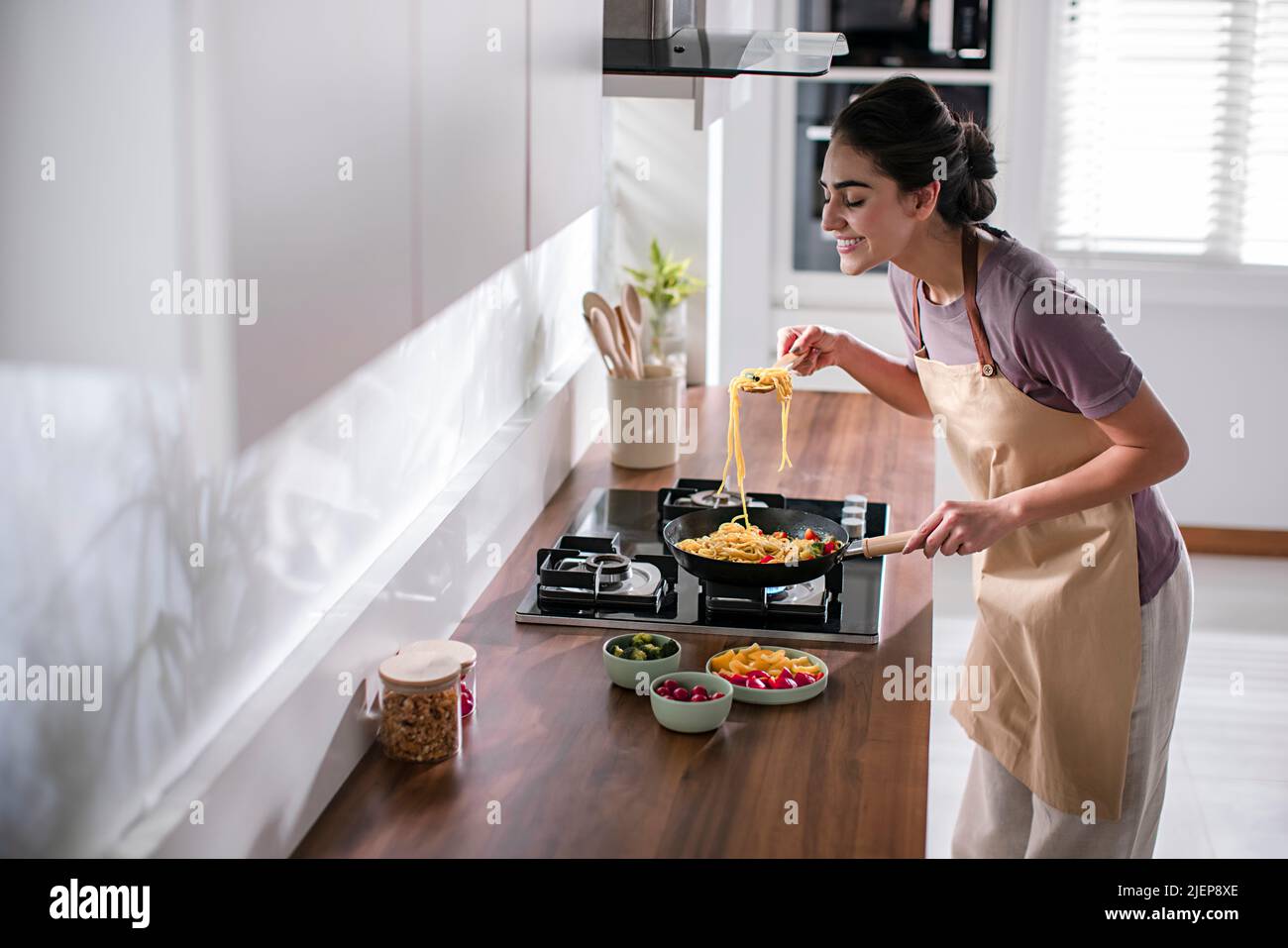 Woman cooking noodles hi-res stock photography and images - Alamy