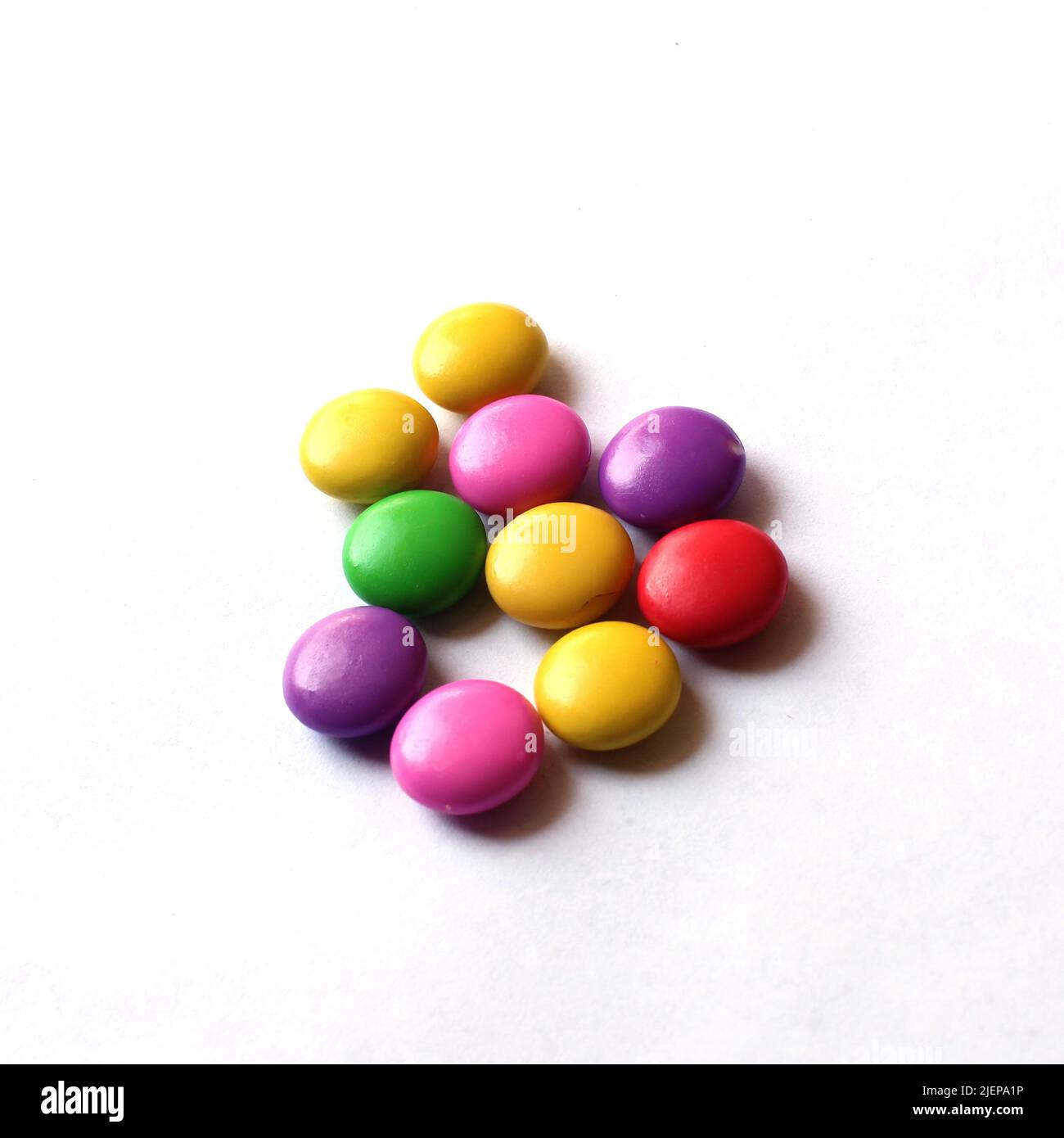 Selective focus of a pile of colorful chocolate buttons on a white ...