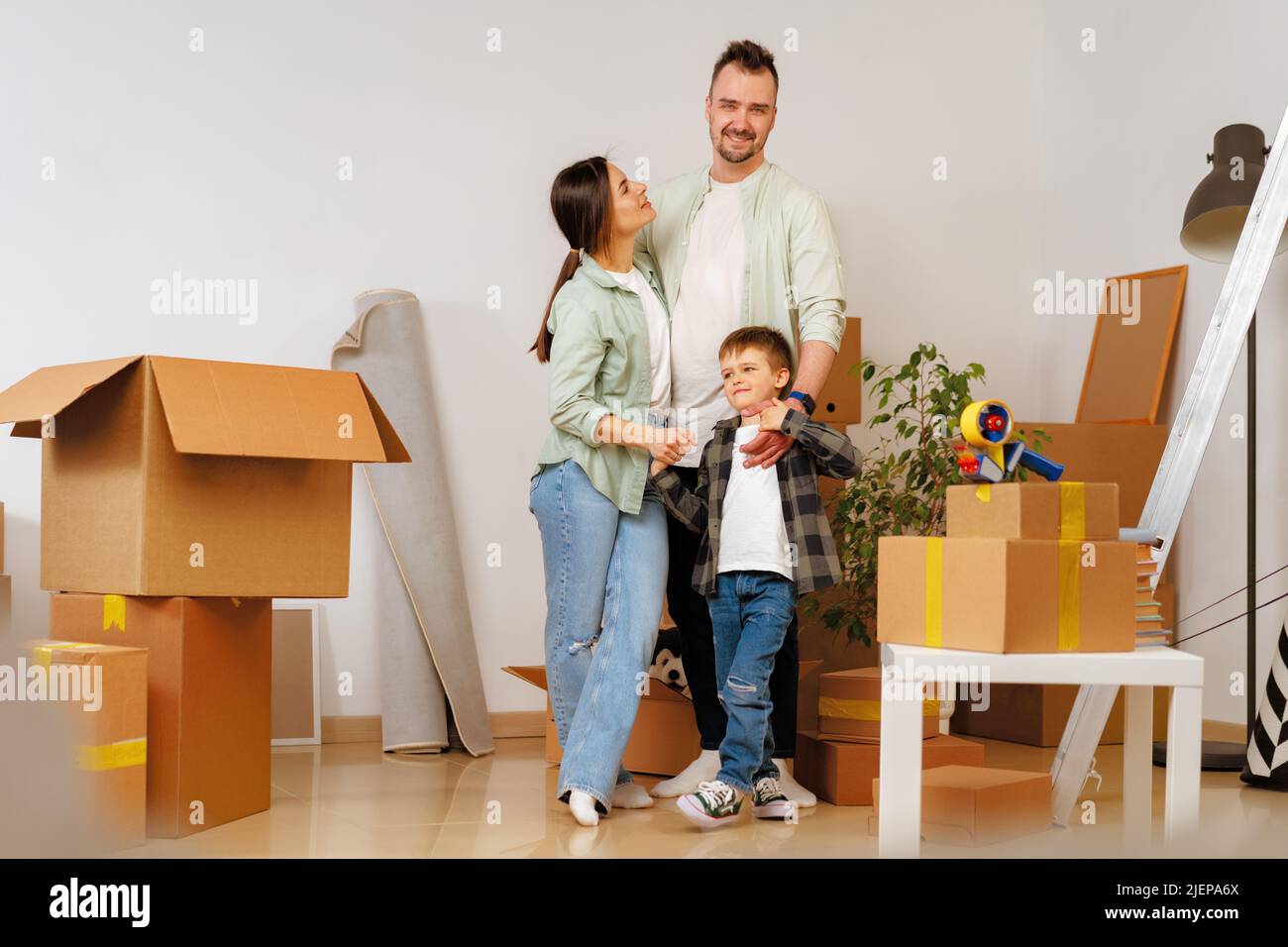 Young parents and son having fun during moving day to new house Stock ...