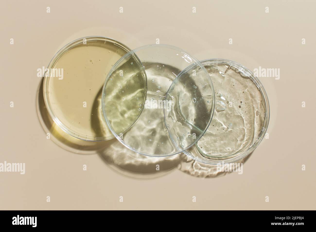 Various cosmetic products in Petri dishes on beige background view from ...
